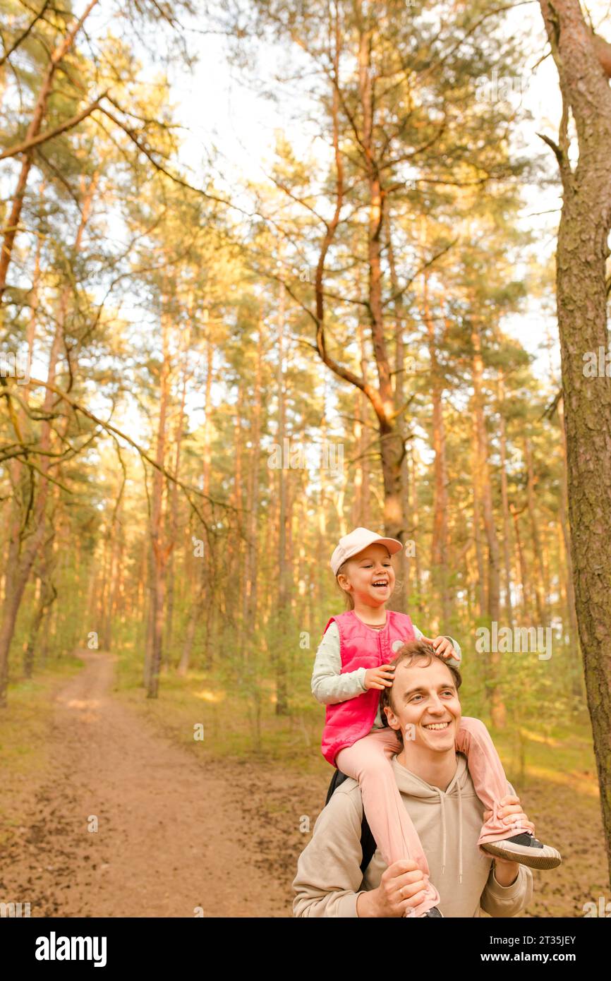 Happy father carrying daughter on shoulder and exploring forest Stock ...