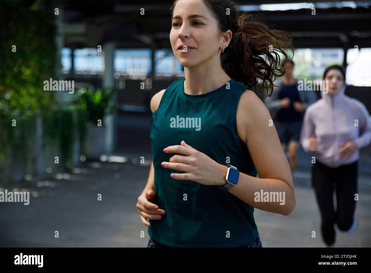 Woman wearing smart watch jogging with friends Stock Photo - Alamy