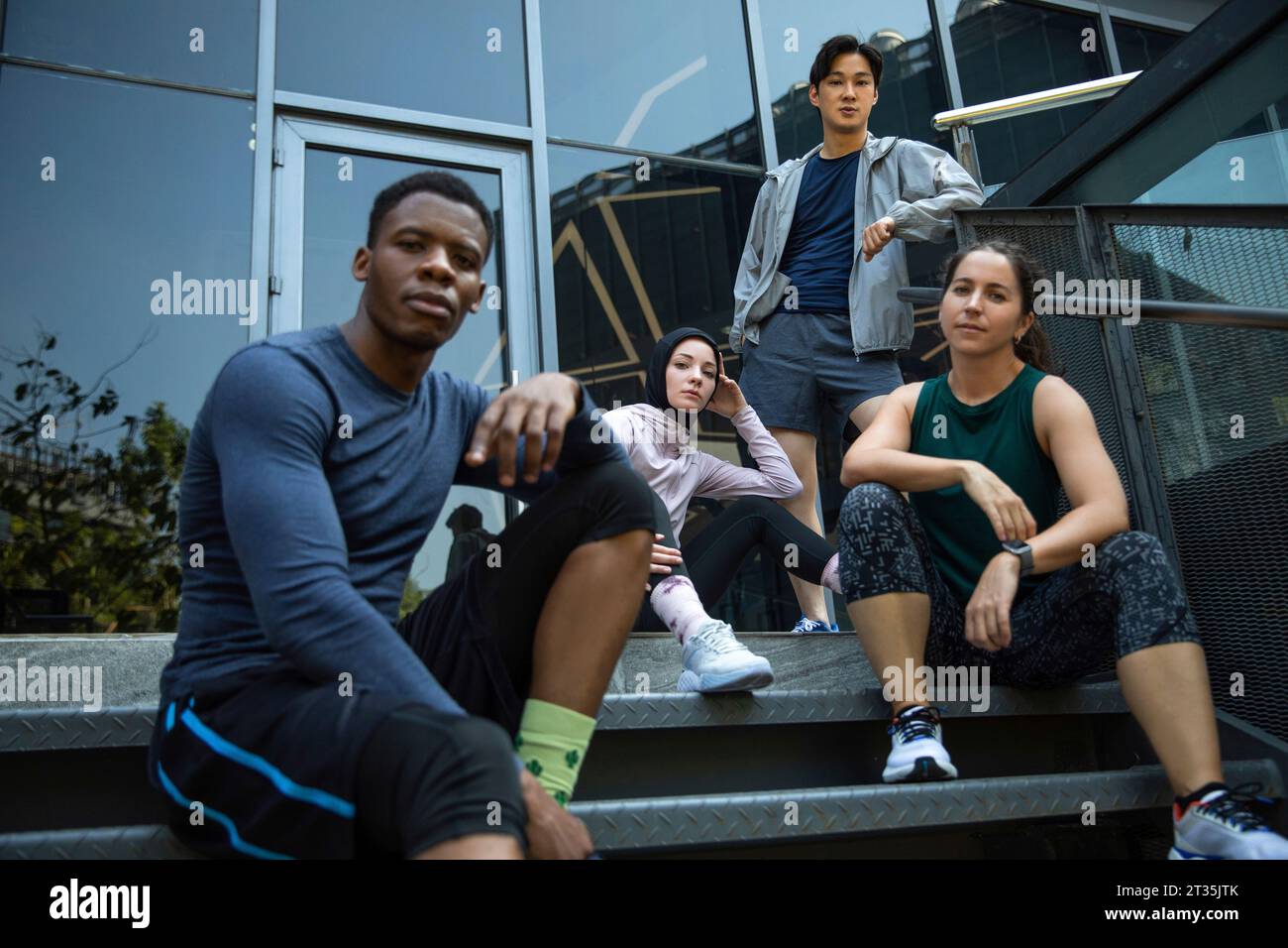 Multiracial friends sitting on steps Stock Photo - Alamy