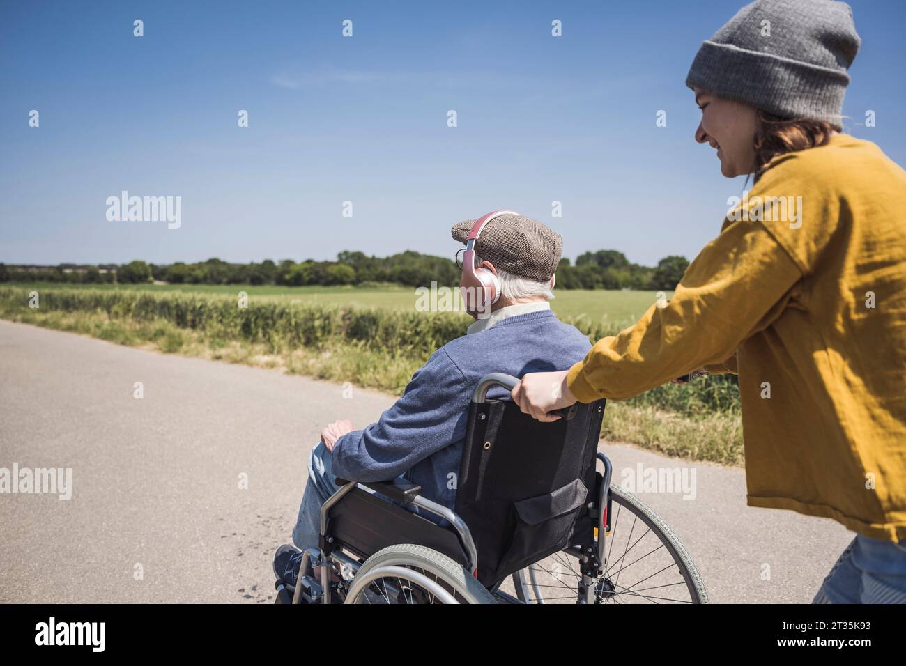 Happy girl pushing wheelchair with grandfather on sunny day Stock Photo ...