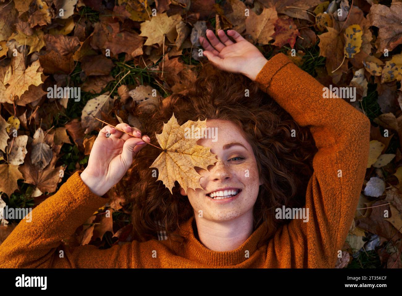 Woman lying holding maple leaf hi-res stock photography and images - Alamy