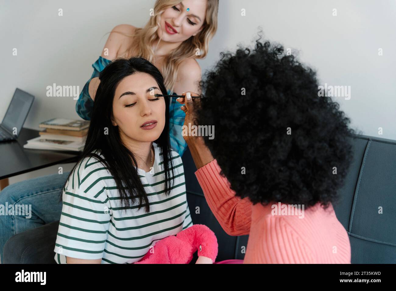 Friends helping woman to get ready with makeup Stock Photo - Alamy