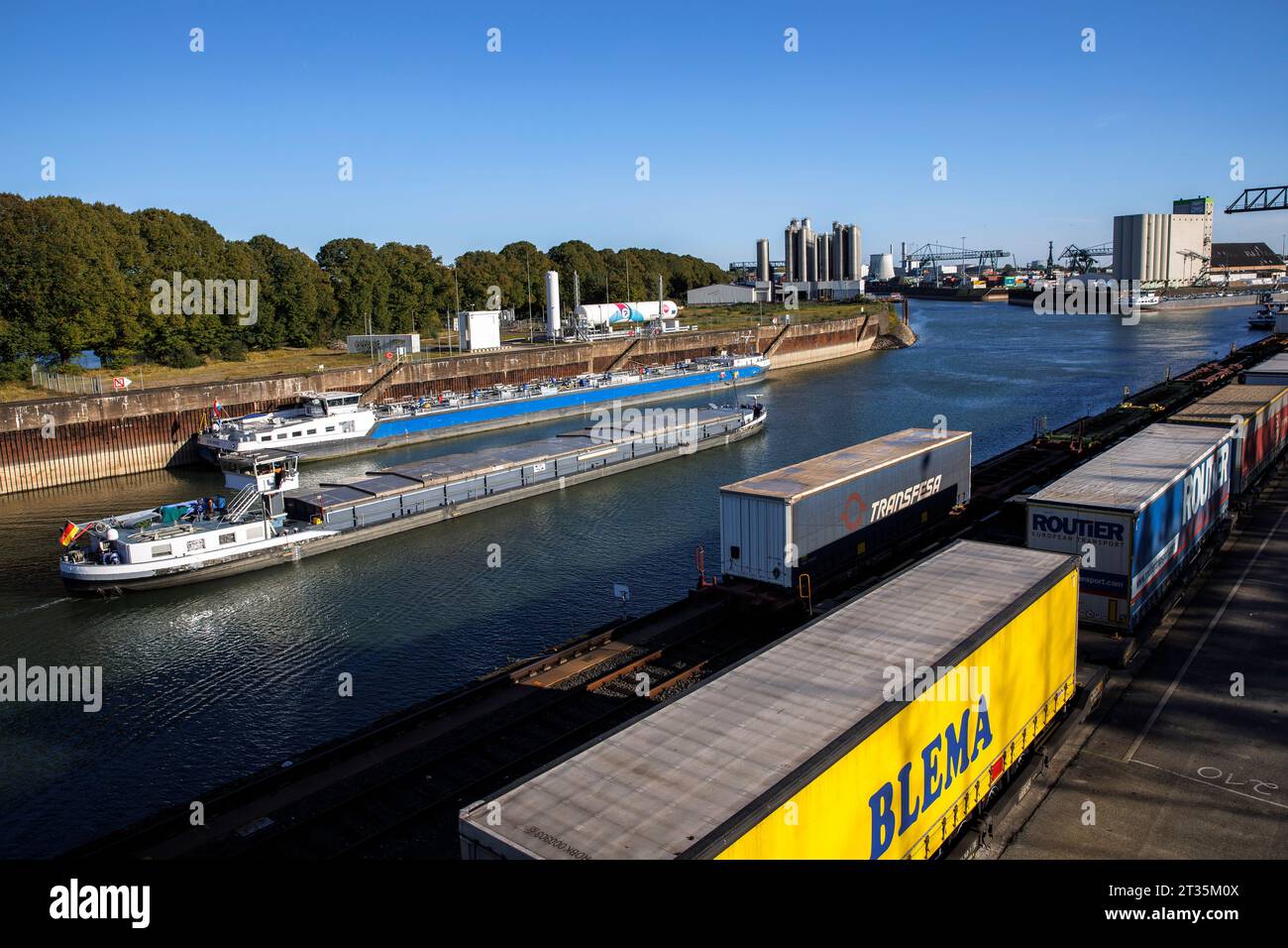 cargo ship entering the Rhine port Niehl, truck trailers standing at ...