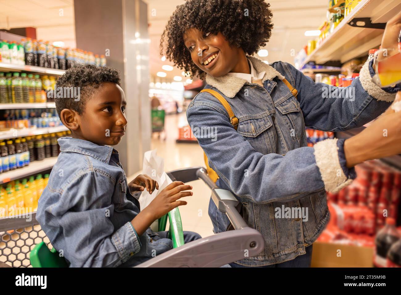 Boy shopping with mother in supermarket Stock Photo - Alamy