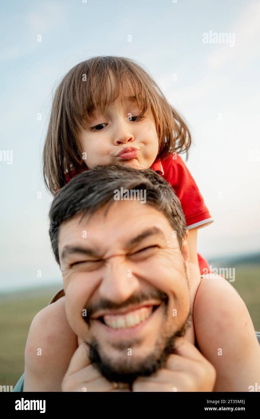 Happy father carrying son on shoulders under sky Stock Photo - Alamy