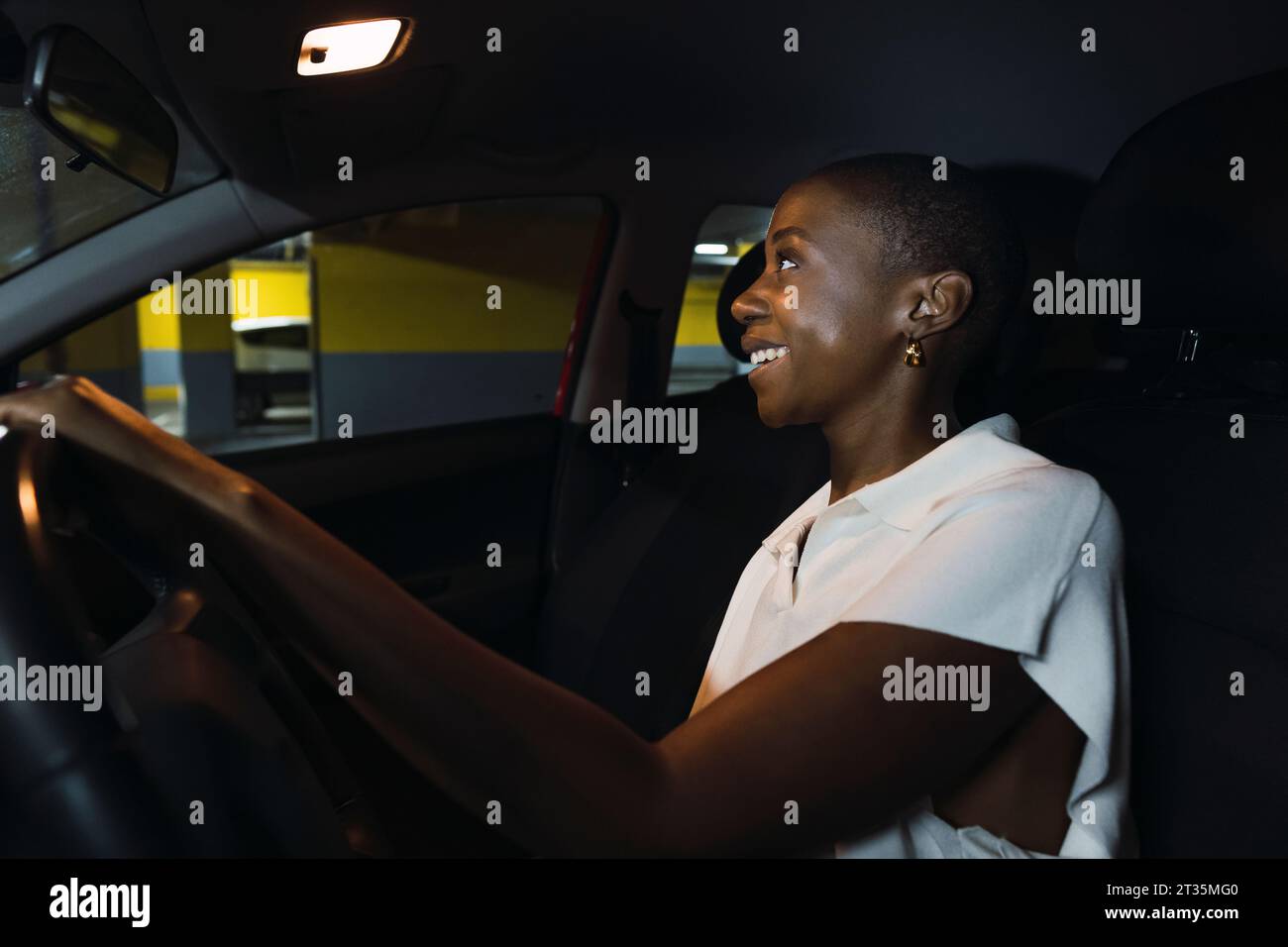 Happy woman driving car in parking garage Stock Photo - Alamy