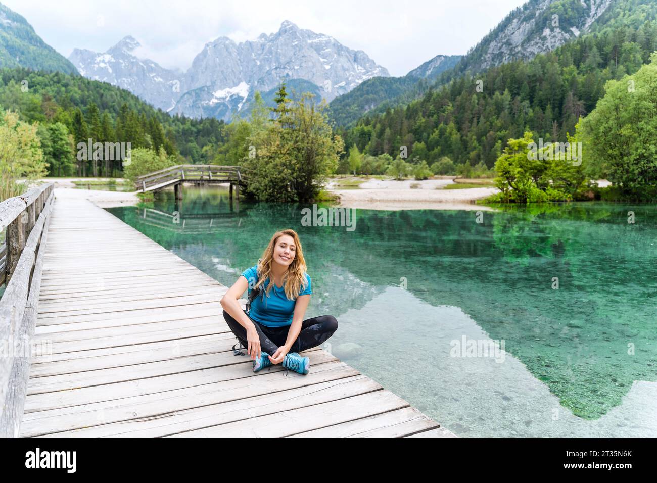 Person sitting pier over lake day hi-res stock photography and images ...