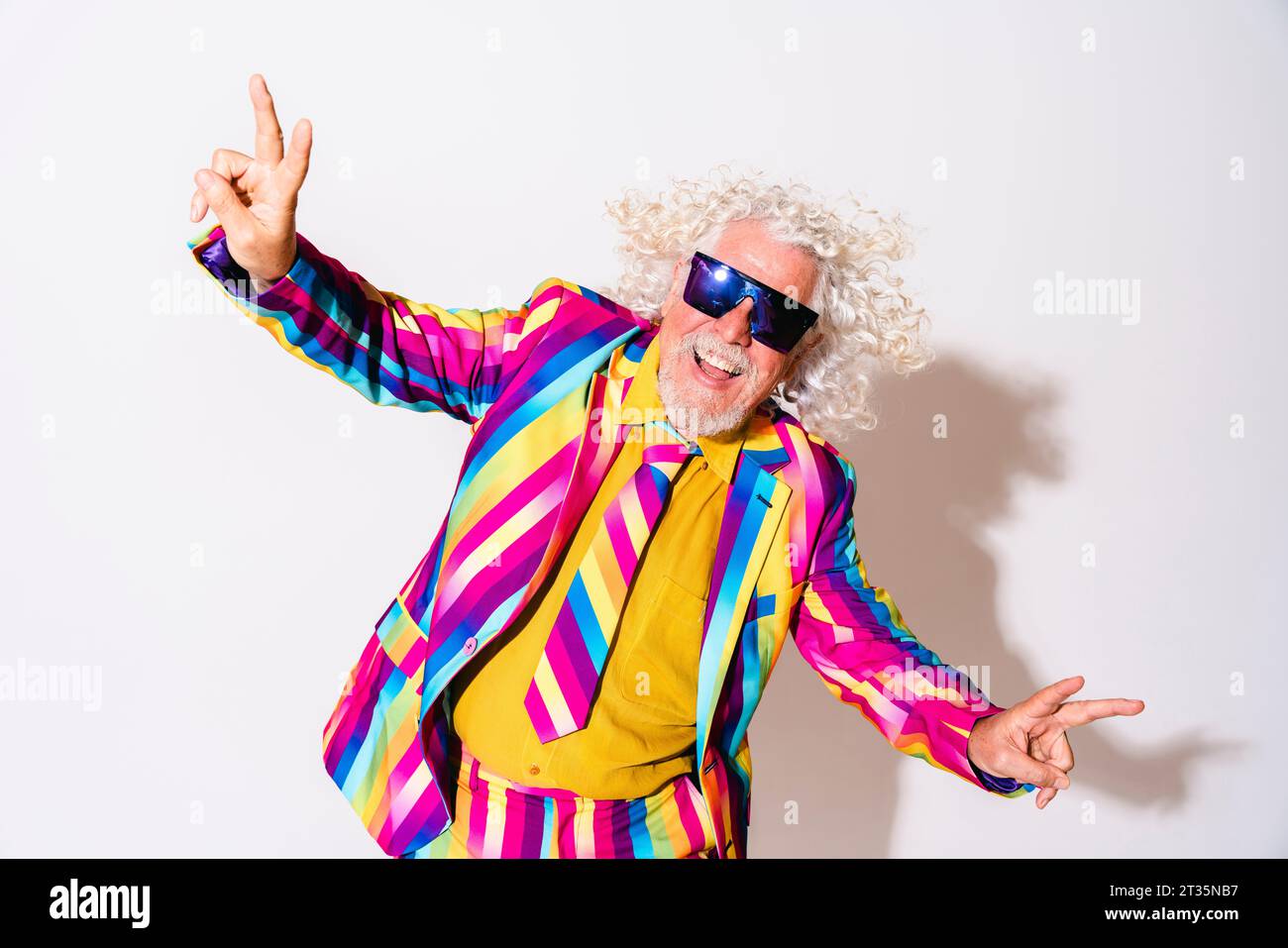 Cheerful man gesturing peace sign against white background Stock Photo ...