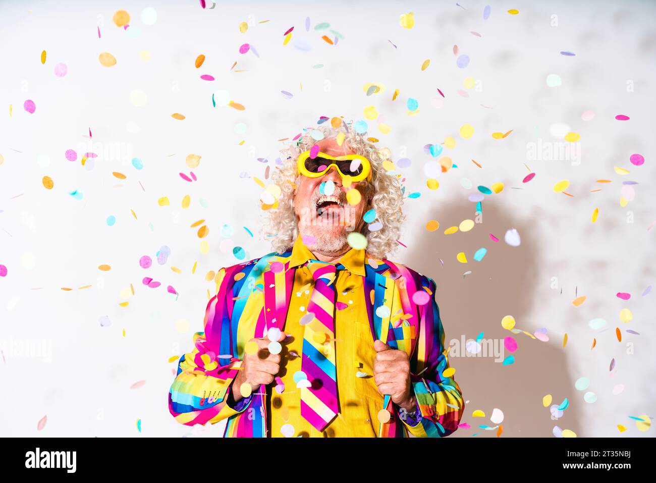 Cheerful senior man with confetti against white background Stock Photo ...