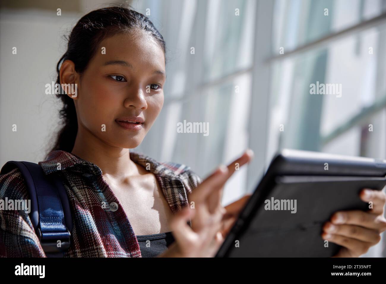 Curious student using tablet PC in university Stock Photo - Alamy
