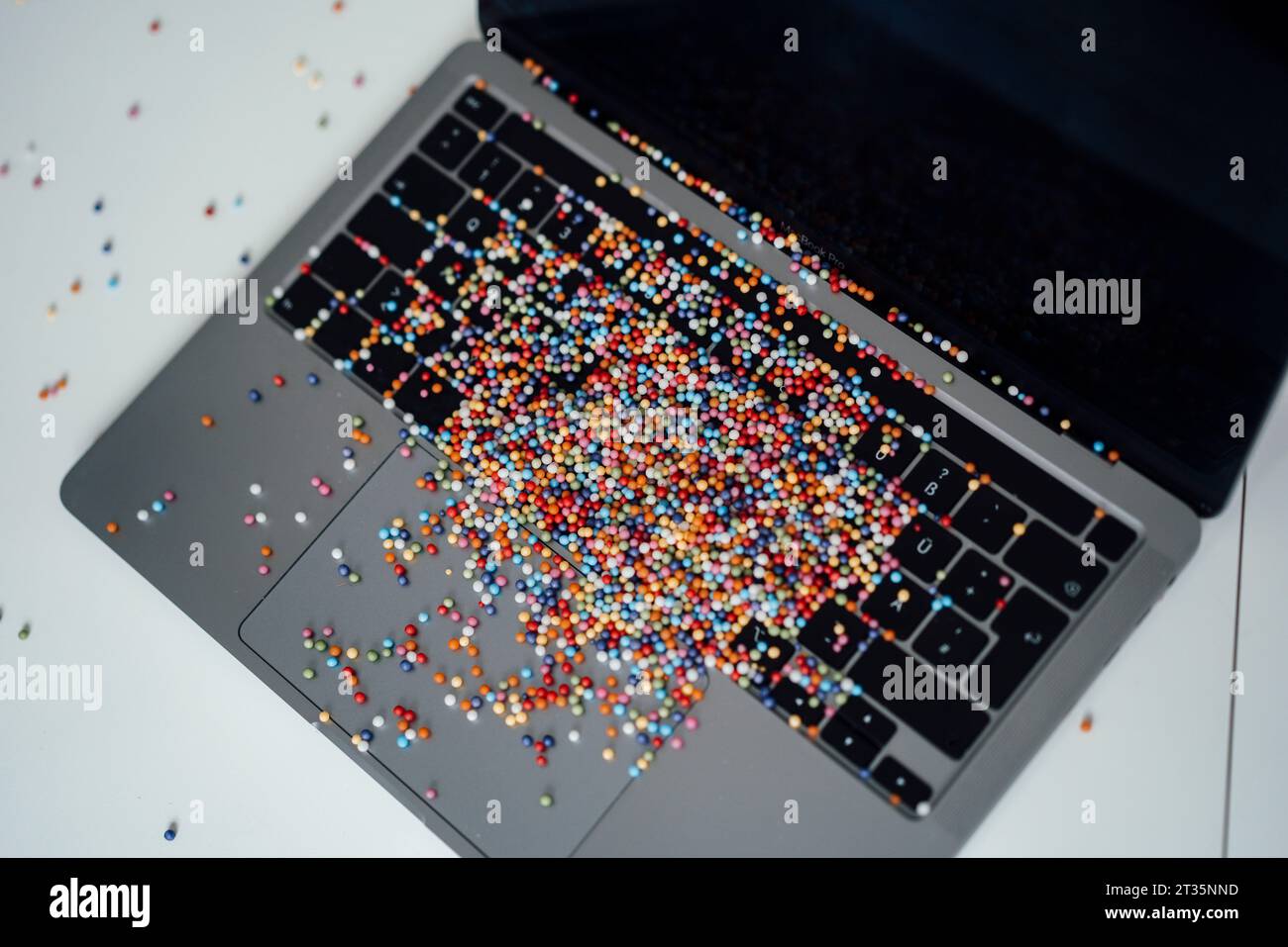 Multi colored pearls on laptop at desk Stock Photo - Alamy