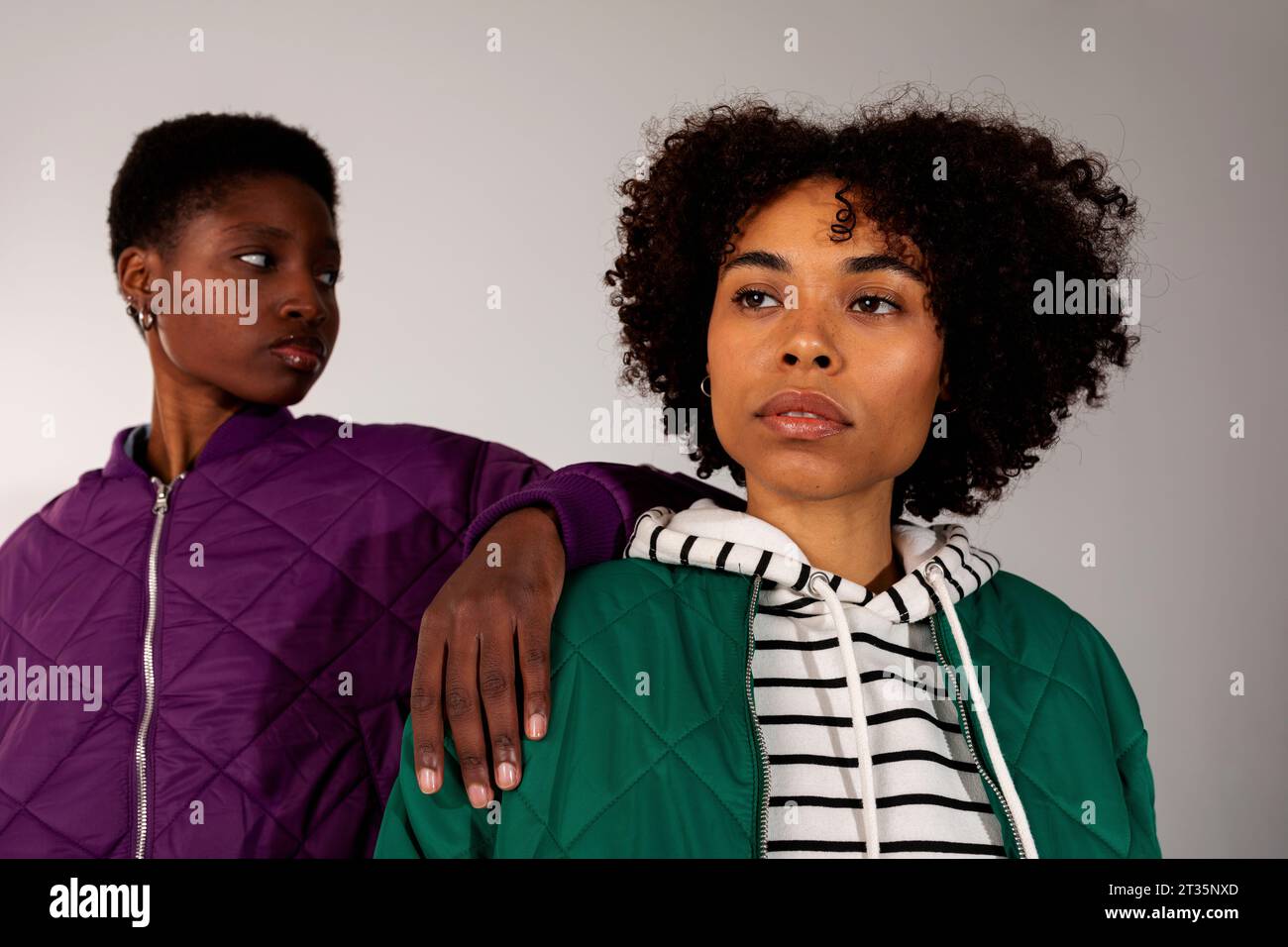 Young women standing together against white background Stock Photo - Alamy
