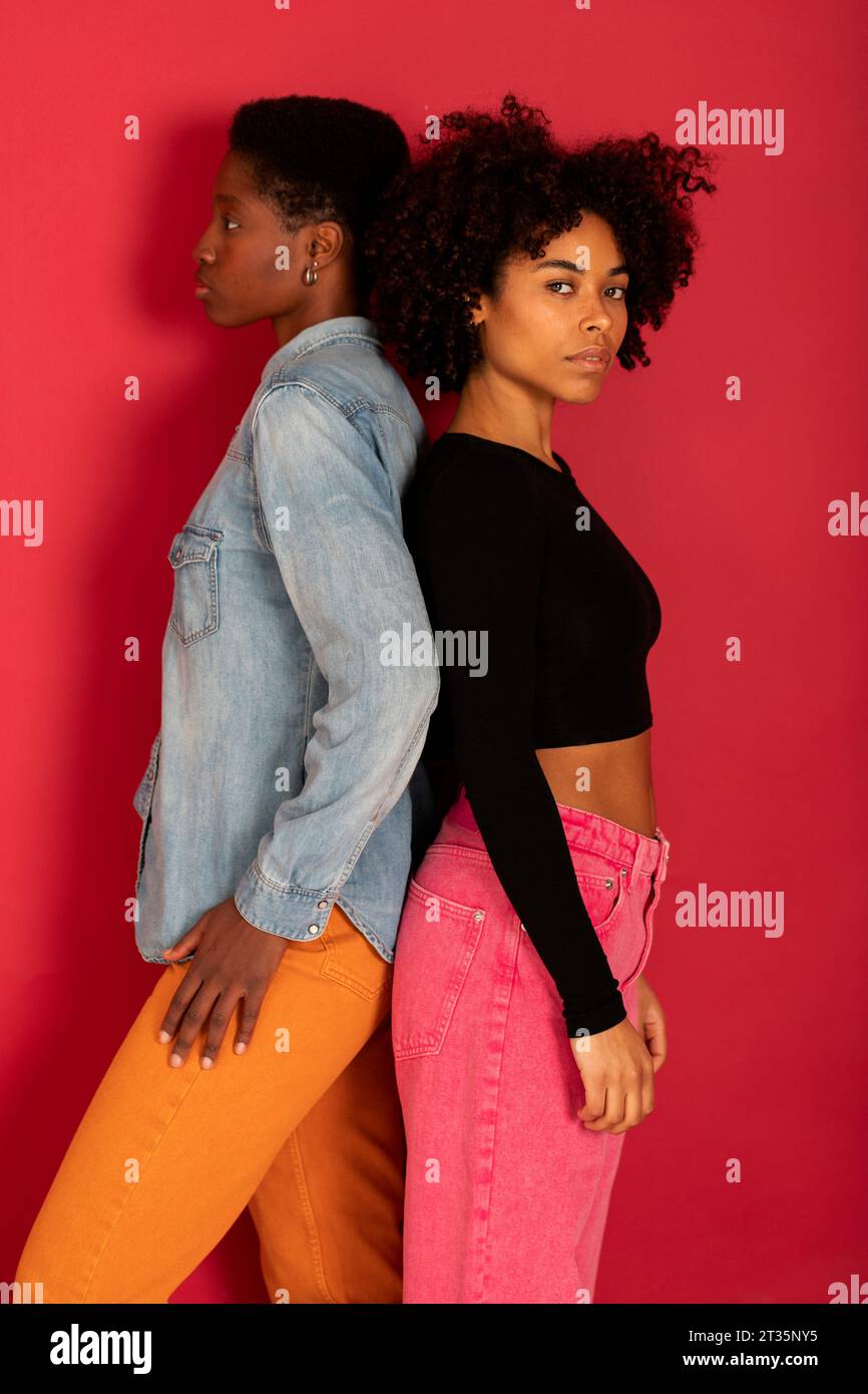 Women standing together against red background Stock Photo - Alamy