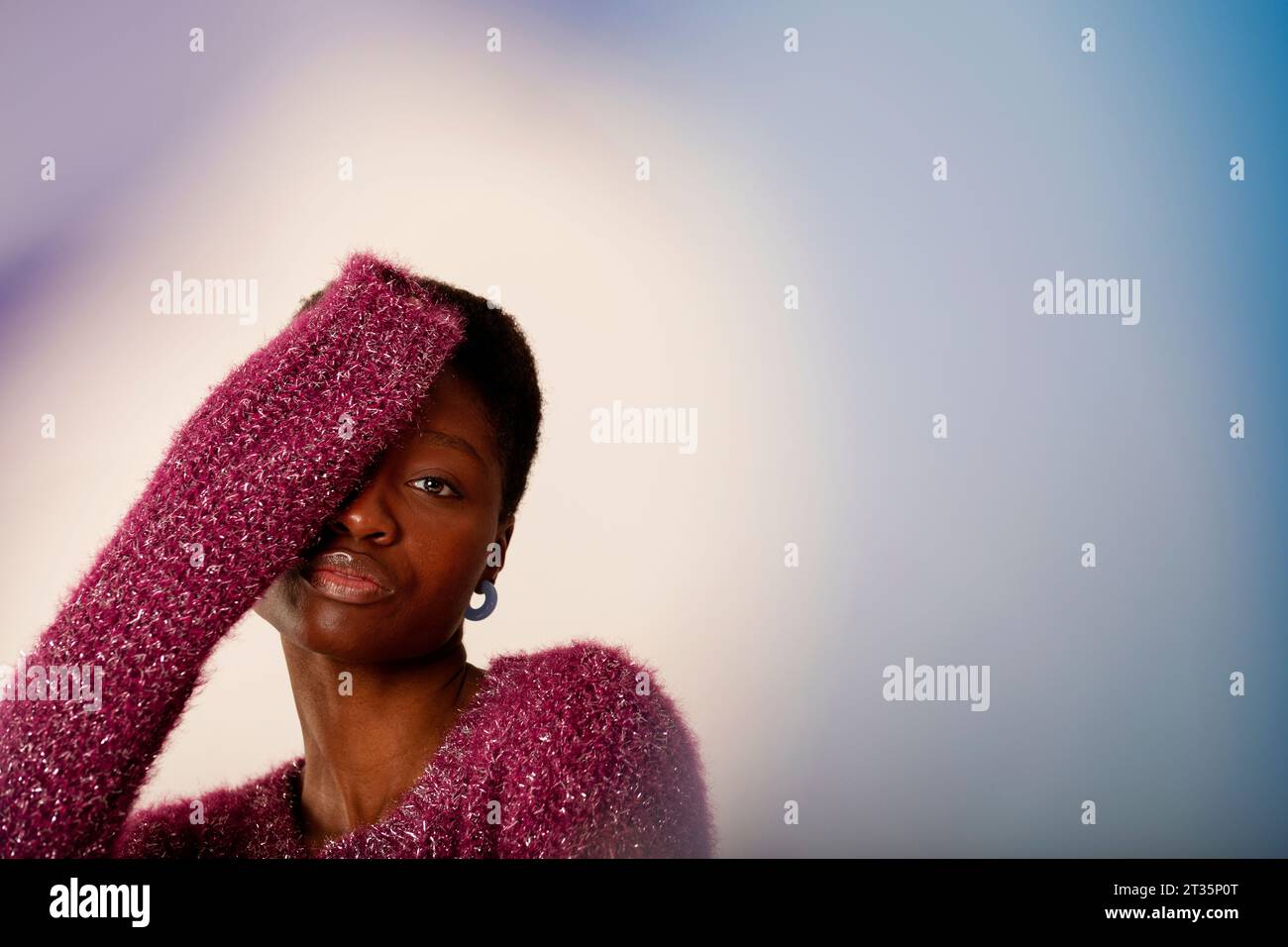 Young woman covering eye with hand against colored background Stock ...