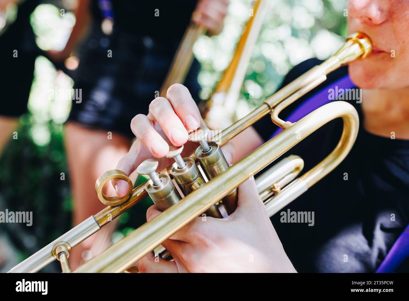 Woman practicing trumpet with group Stock Photo - Alamy