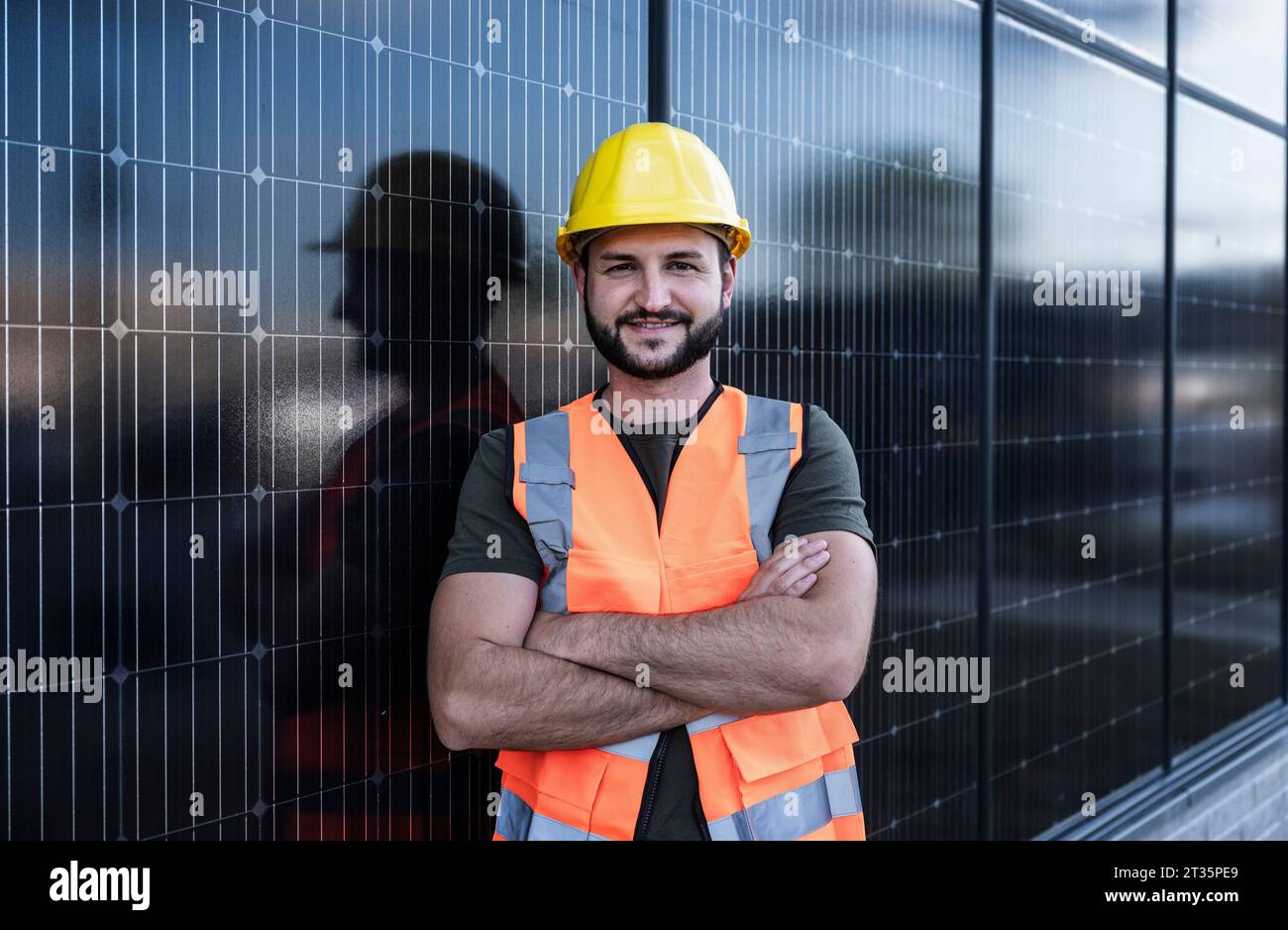 Smiling engineer leaning with arms crossed on solar panels Stock Photo ...