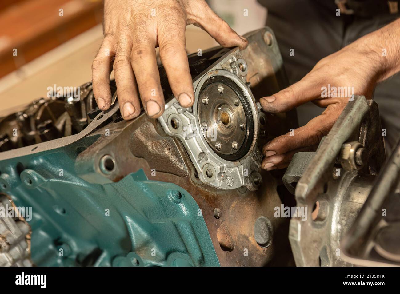 Close-up of a mechanic s hands meticulously assembling a vintage engine ...