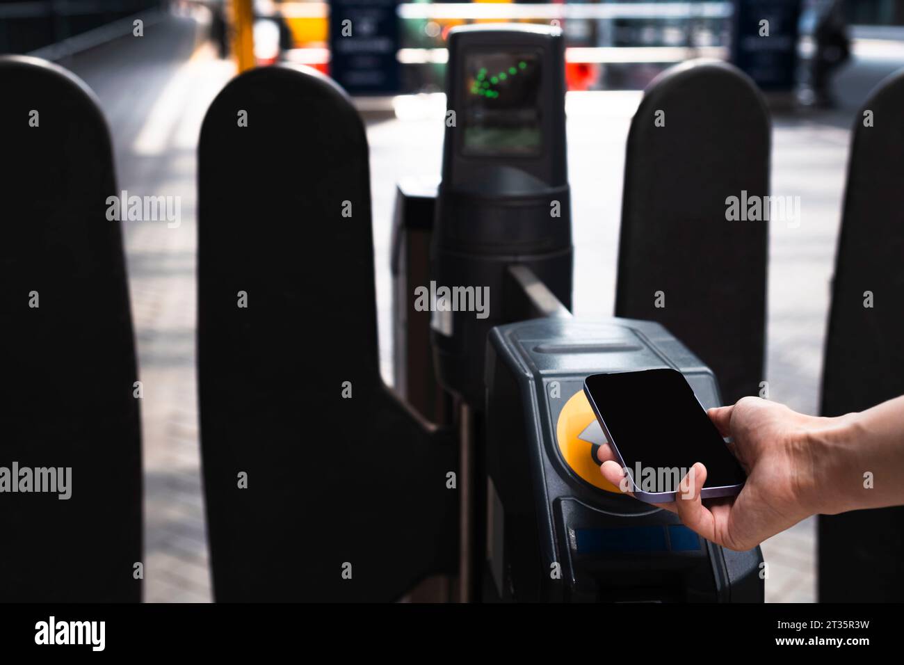 Businesswoman scanning turnstile with smart phone at railroad station ...