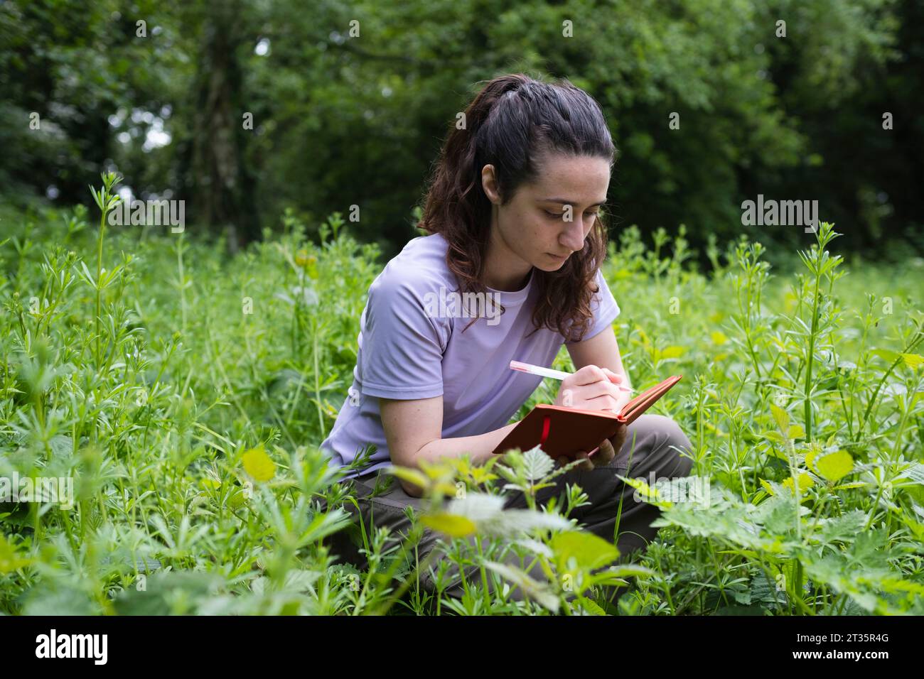 Woman of colour writing in nature hi-res stock photography and images ...