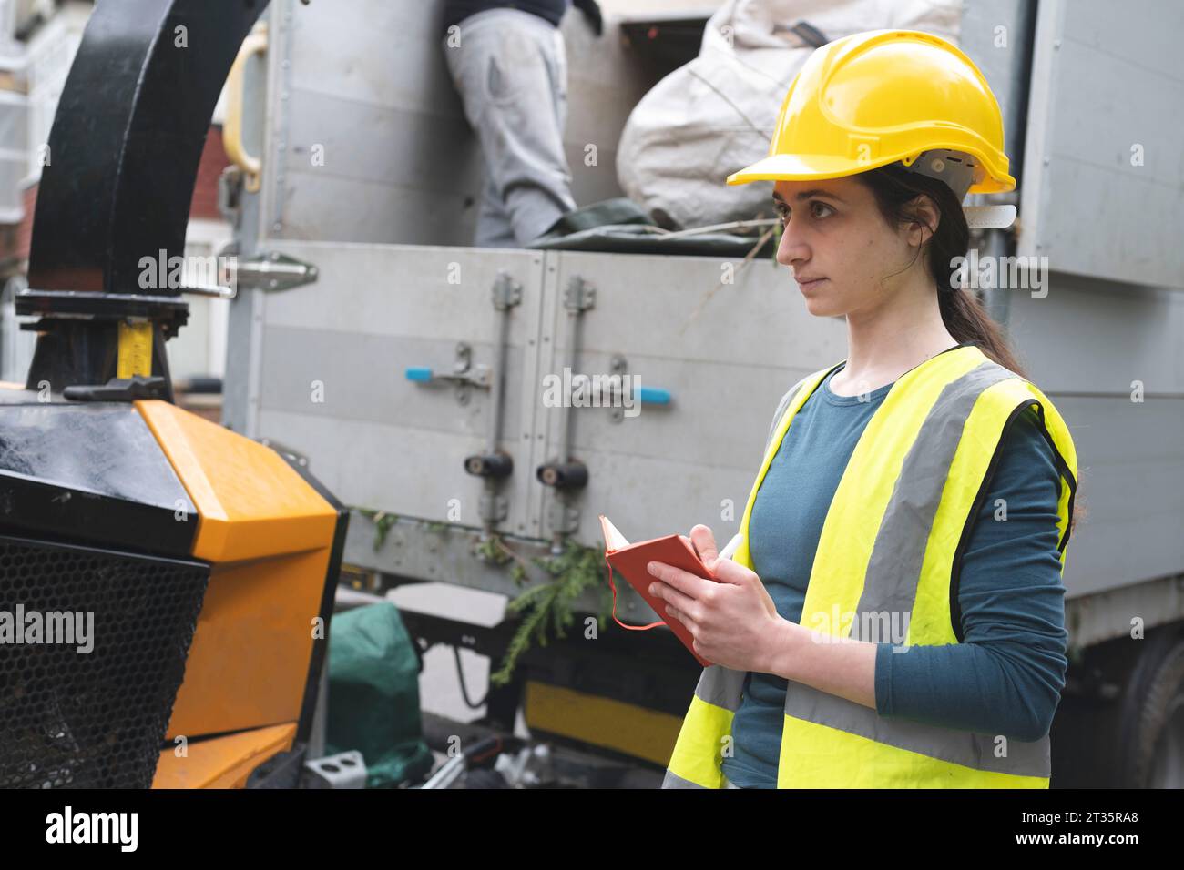 Serious blue collar worker writing in diary near dumper truck Stock ...