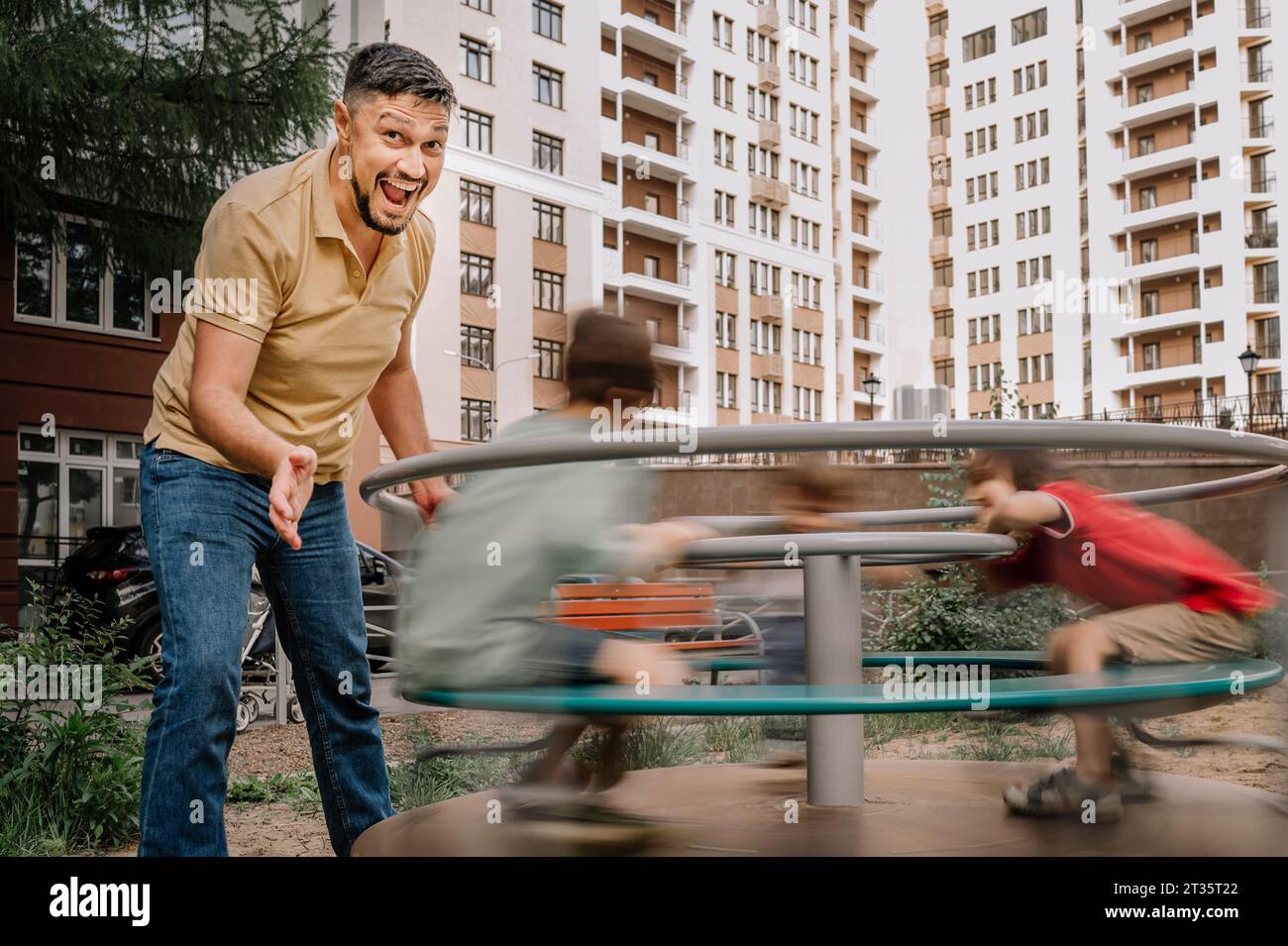 Happy father spinning children on merry-go-round Stock Photo - Alamy