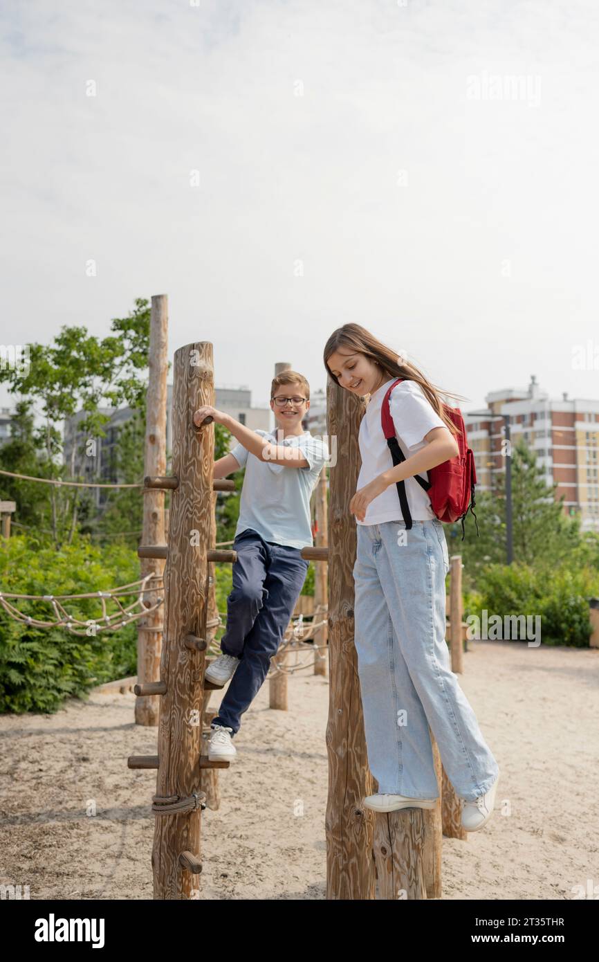 Friends playing together on wooden pole at playground Stock Photo - Alamy