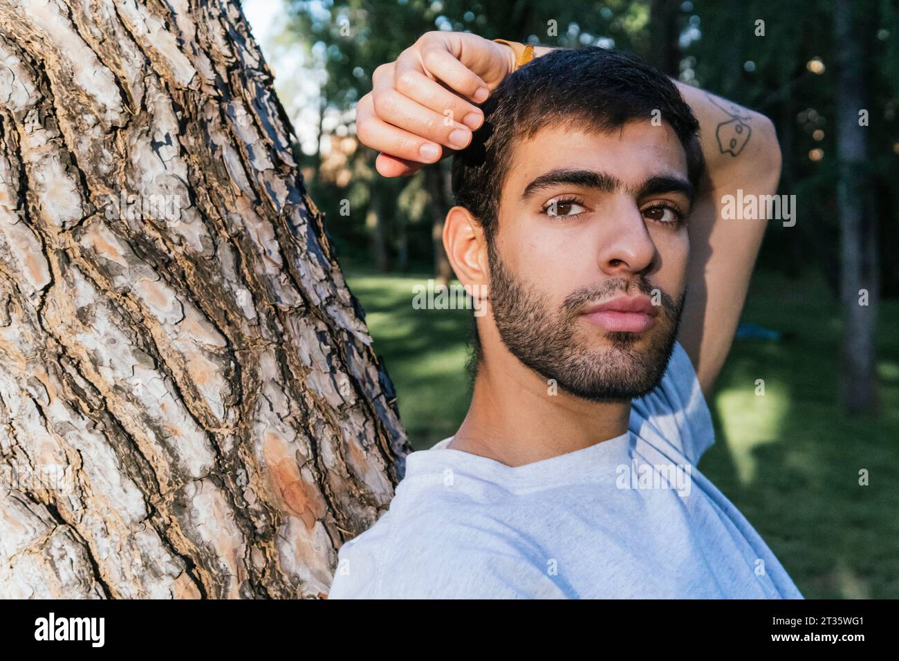 Young man leaning tree trunk park hi-res stock photography and images ...