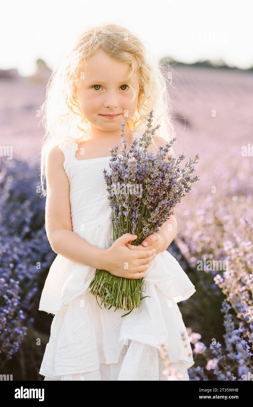 Girl in white holding flowers hi-res stock photography and images - Alamy