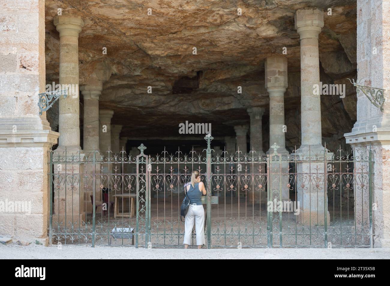 Young tourist girl photographing the cave grotto in the stone with the ...
