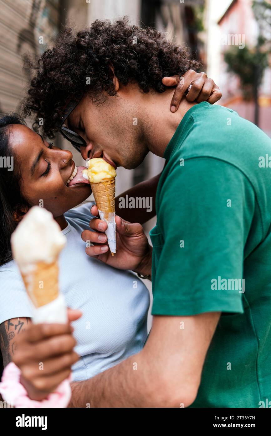 Happy couple sharing ice cream cone Stock Photo - Alamy
