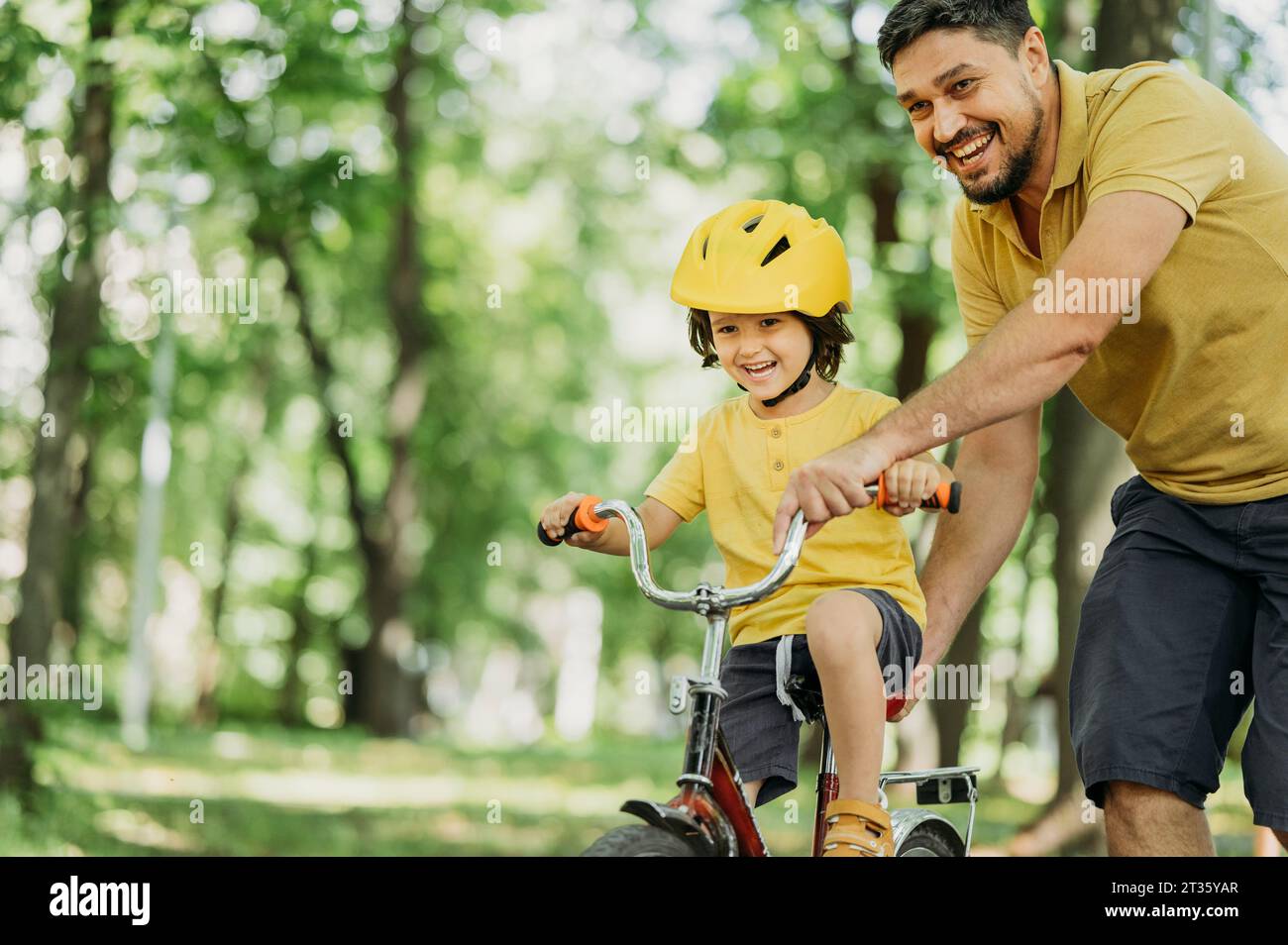 Father and son enjoying cycling at park Stock Photo - Alamy