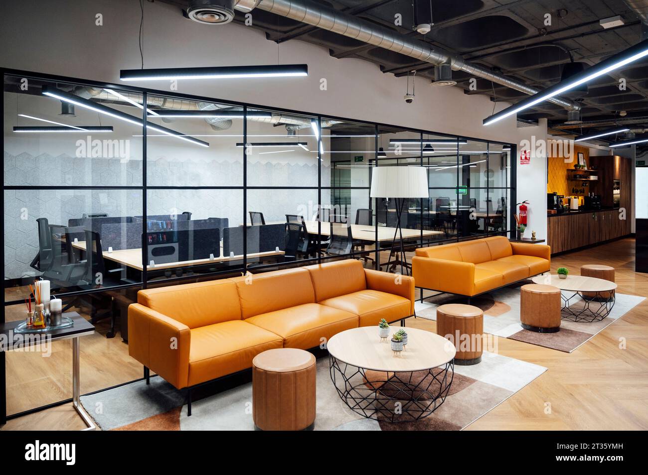 Illuminated office with furniture and coffee tables Stock Photo - Alamy