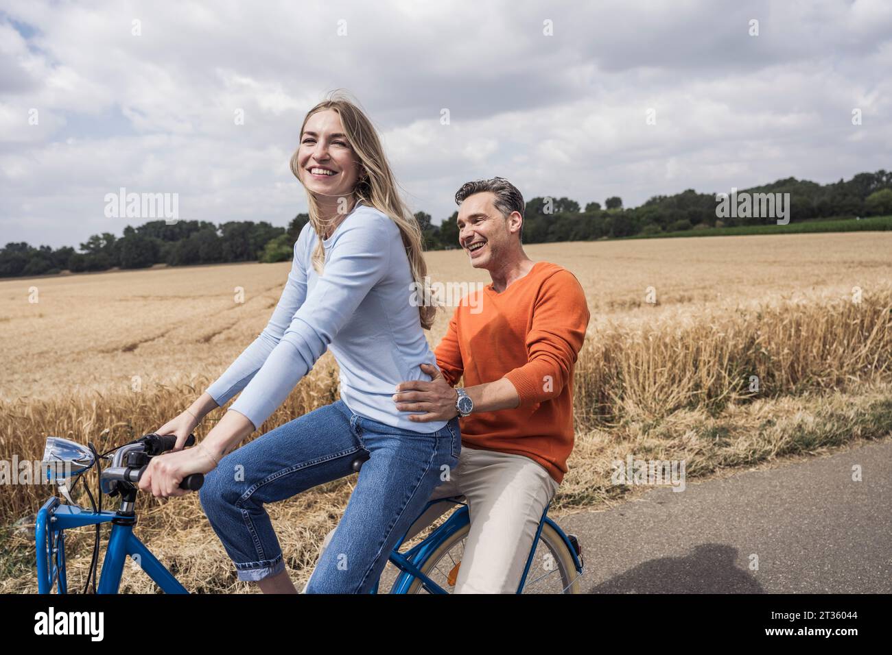Happy couple enjoying bicycle ride together Stock Photo - Alamy