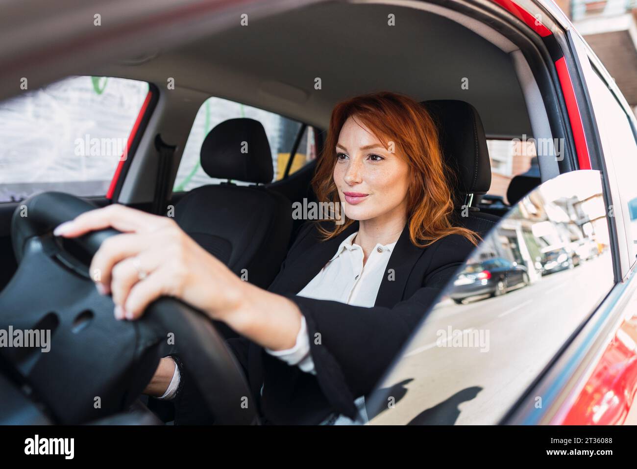Smiling redhead businesswoman driving car Stock Photo - Alamy