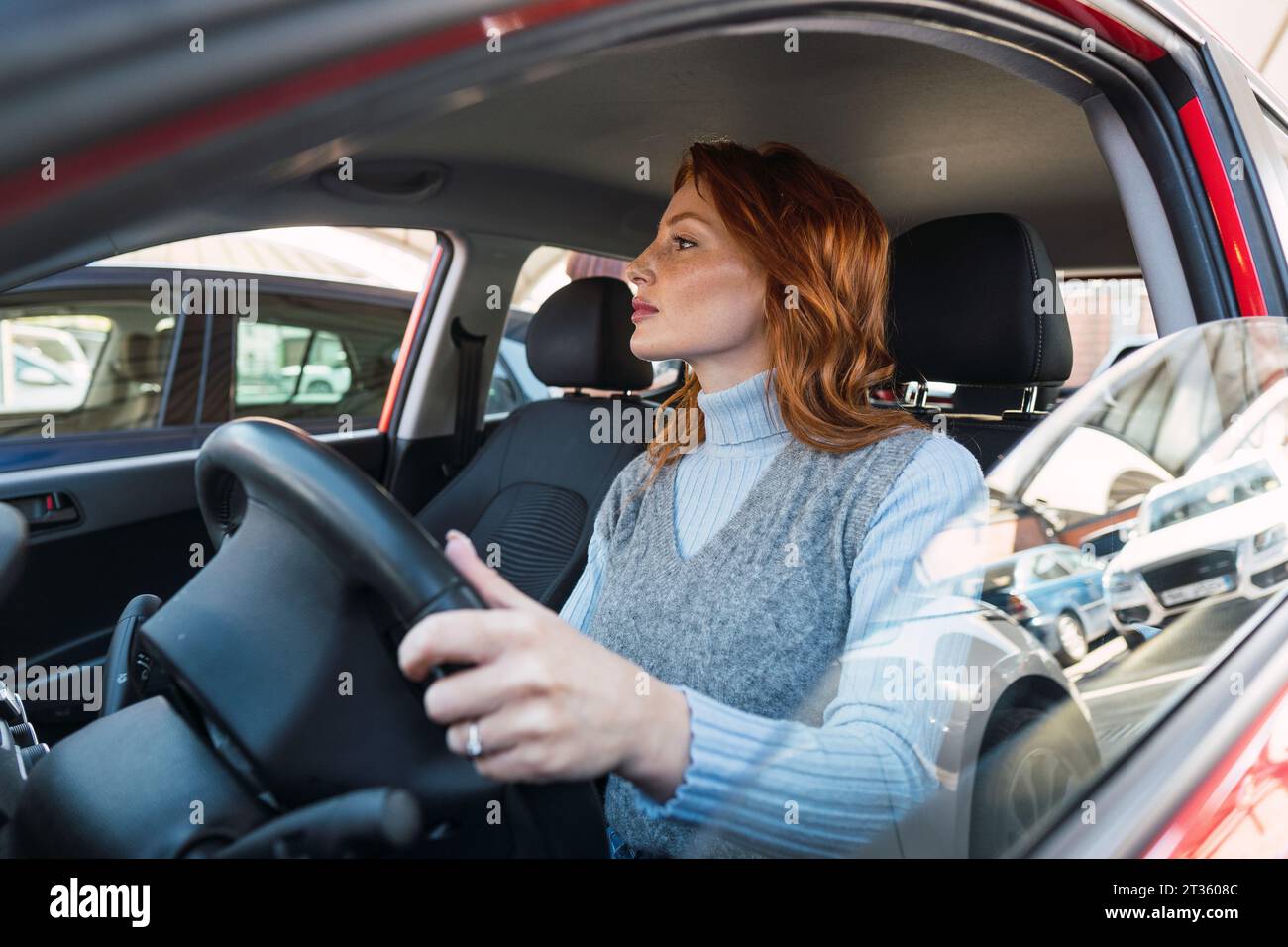 Redhead woman inside car parking Stock Photo - Alamy