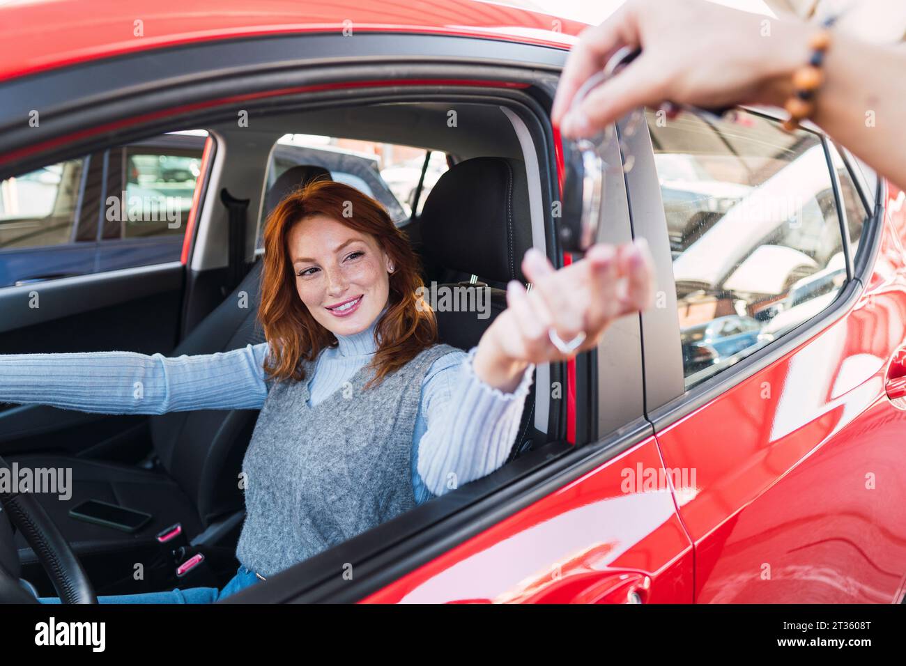 Smiling woman taking car keys from man Stock Photo - Alamy