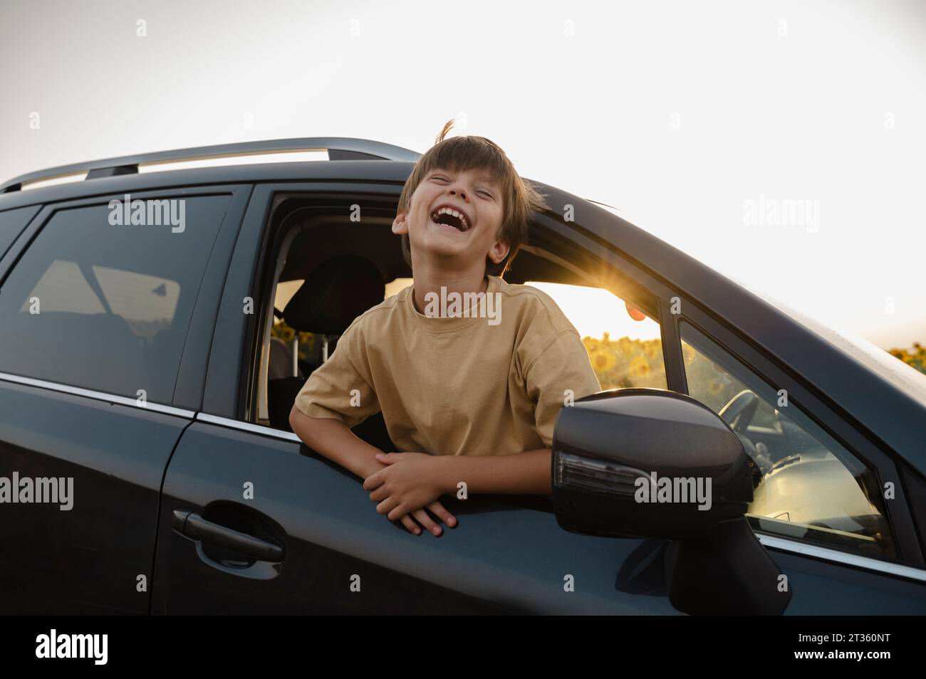 Cheerful boy leaning outside car window Stock Photo - Alamy