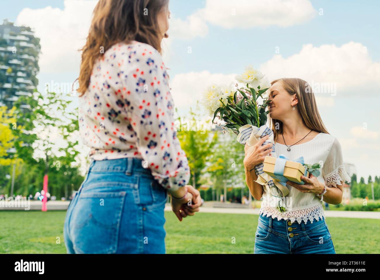 Woman smelling flower in park hi-res stock photography and images - Alamy