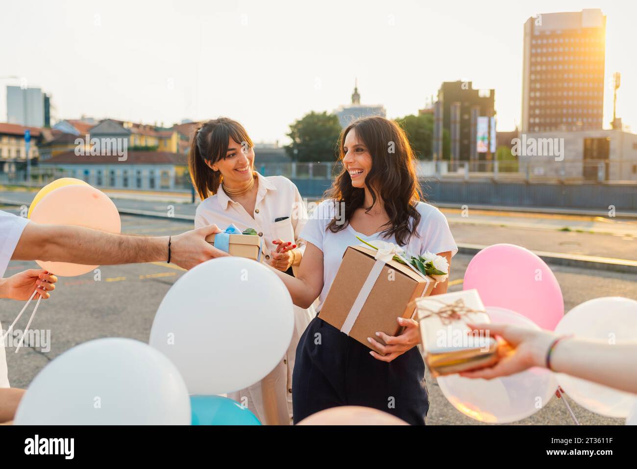 Happy woman with friends giving gifts and celebrating birthday together ...