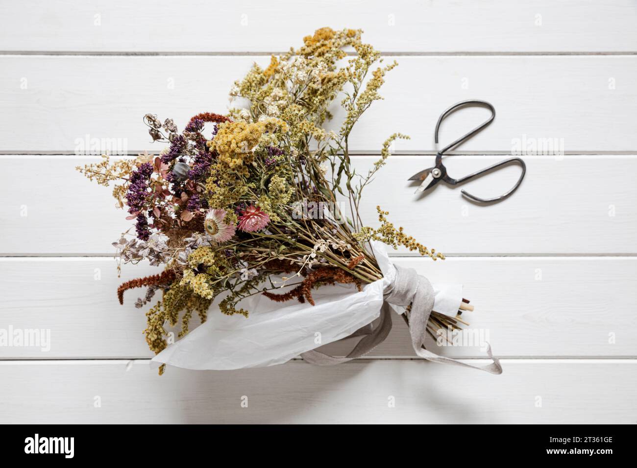 Bouquet of dried flowers lying on white painted wood Stock Photo - Alamy