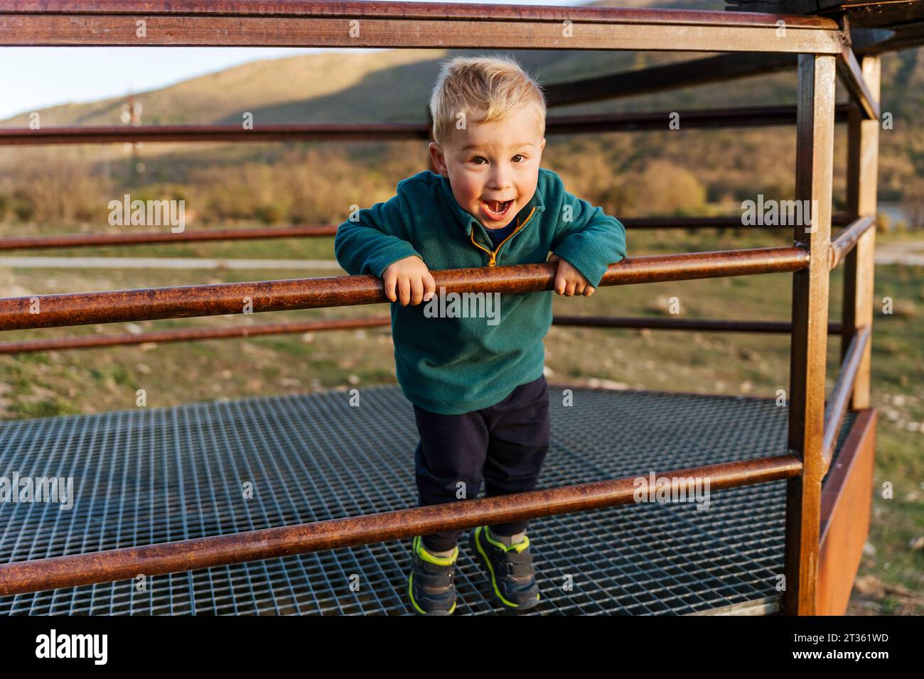 Cheerful boy screaming at railing Stock Photo - Alamy