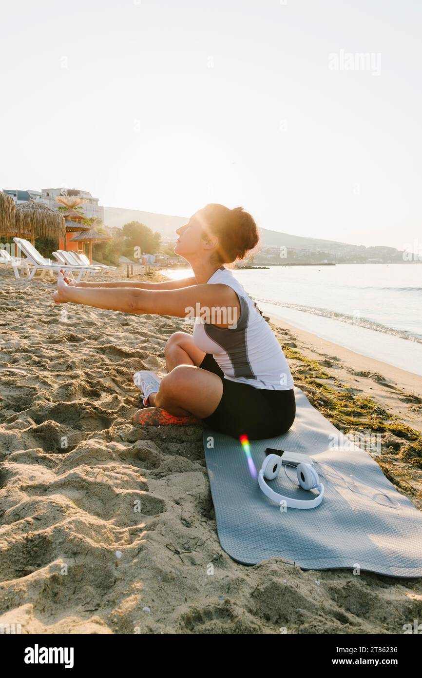 Woman sitting on beach stretching hi-res stock photography and images ...