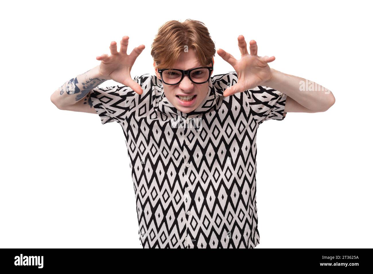 young upset angry caucasian ginger man with a tattoo on his arms is ...