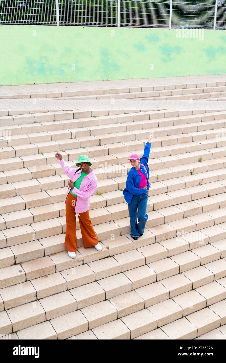 Non-binary person dancing with woman on staircase Stock Photo - Alamy