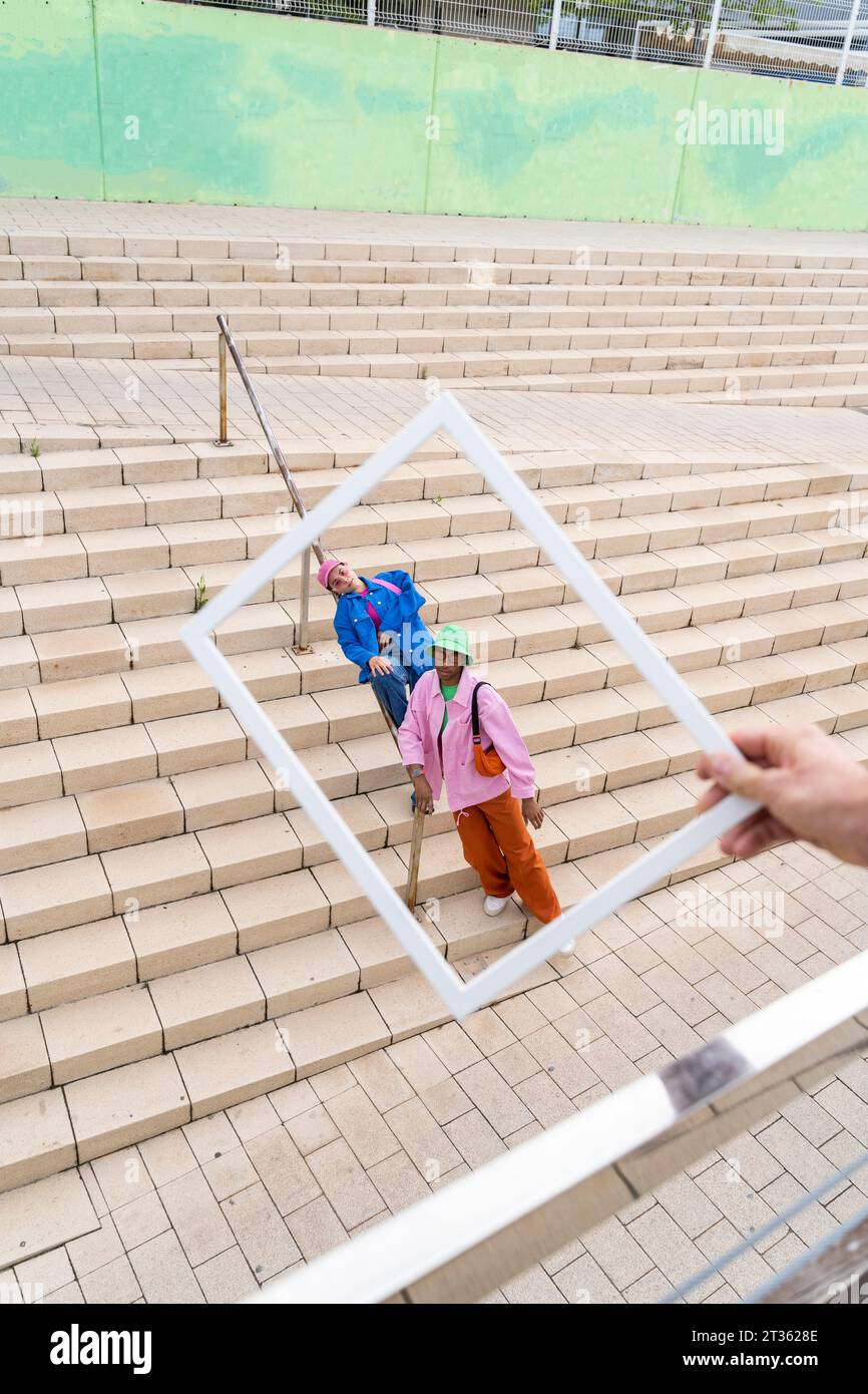 Hand holding picture frame with friends on steps Stock Photo - Alamy
