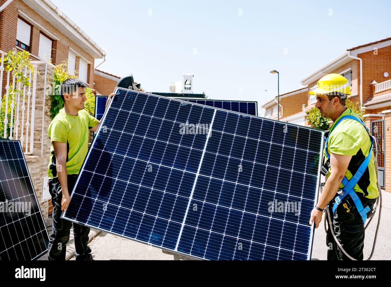 Engineer carrying solar panel with colleague on sunny day Stock Photo ...