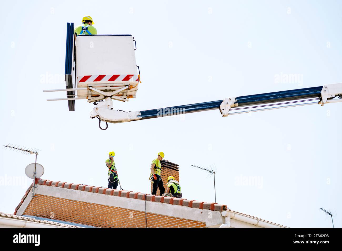 Engineers with colleague holding solar panel on hydraulic platform ...