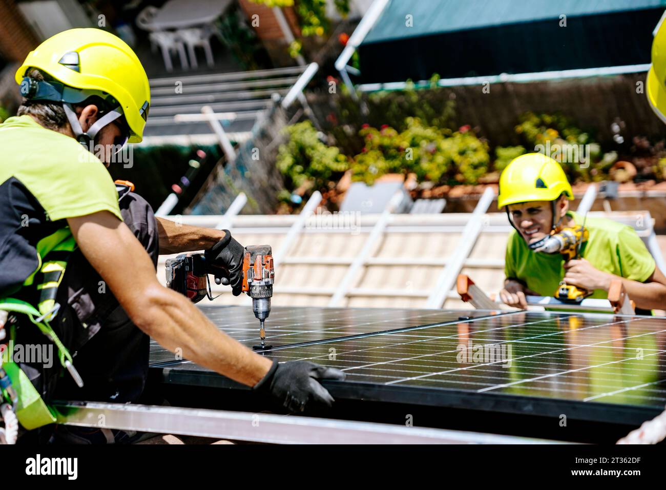 Engineers with drill machine installing solar panels on roof Stock ...