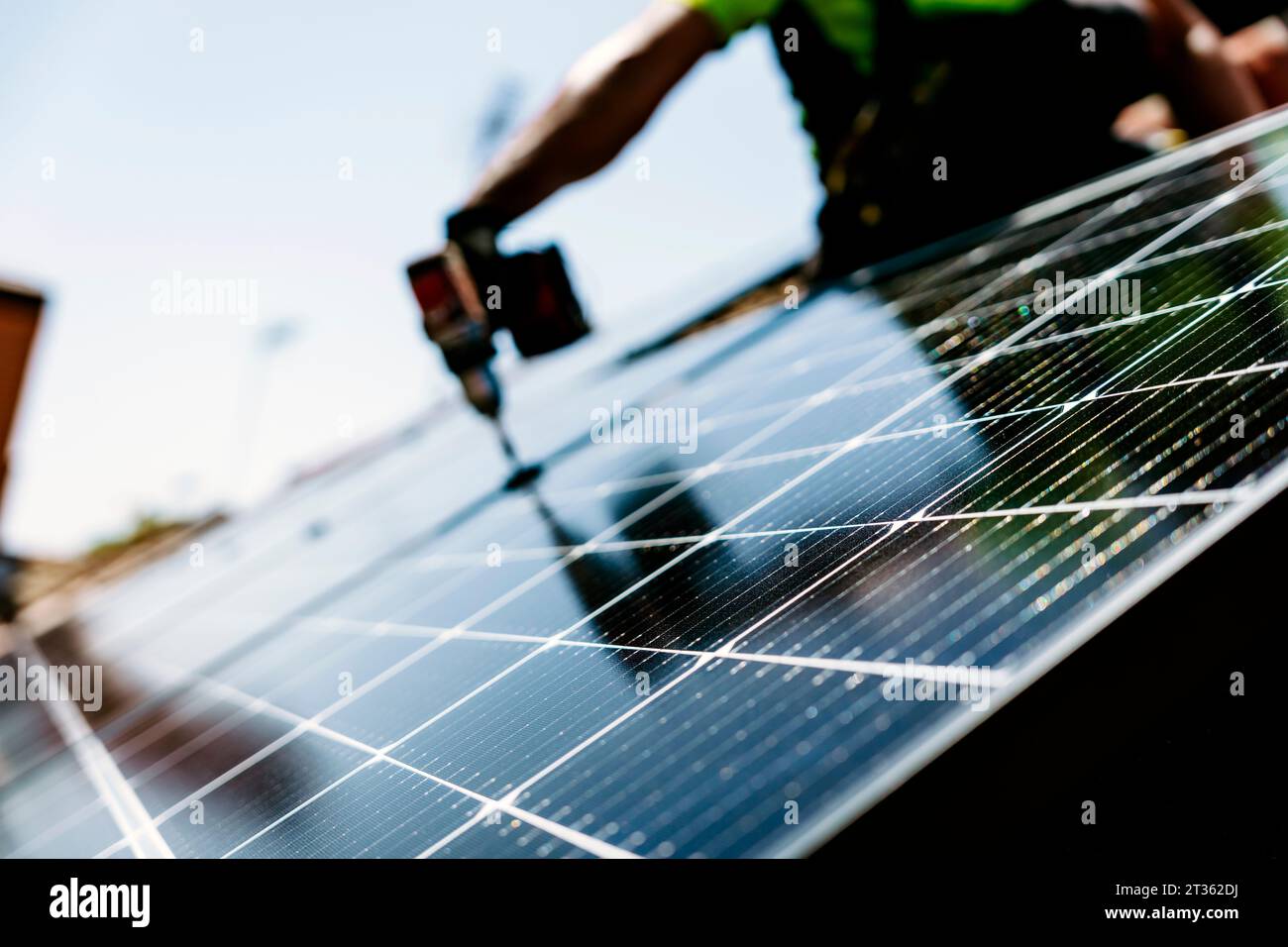 Engineer with drill machine installing solar panels on roof Stock Photo ...
