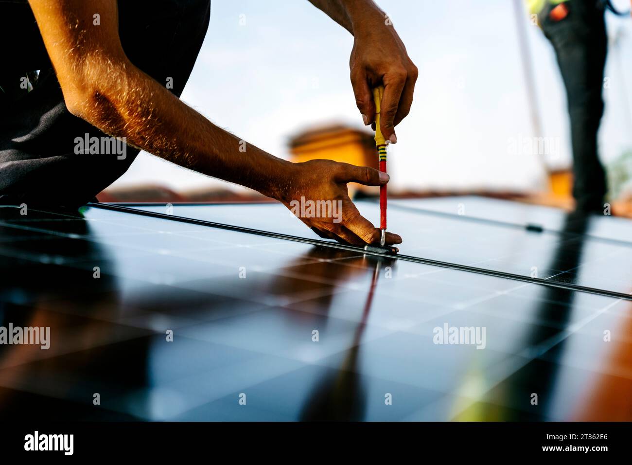 Hands of engineer using screwdriver to install solar panels Stock Photo ...